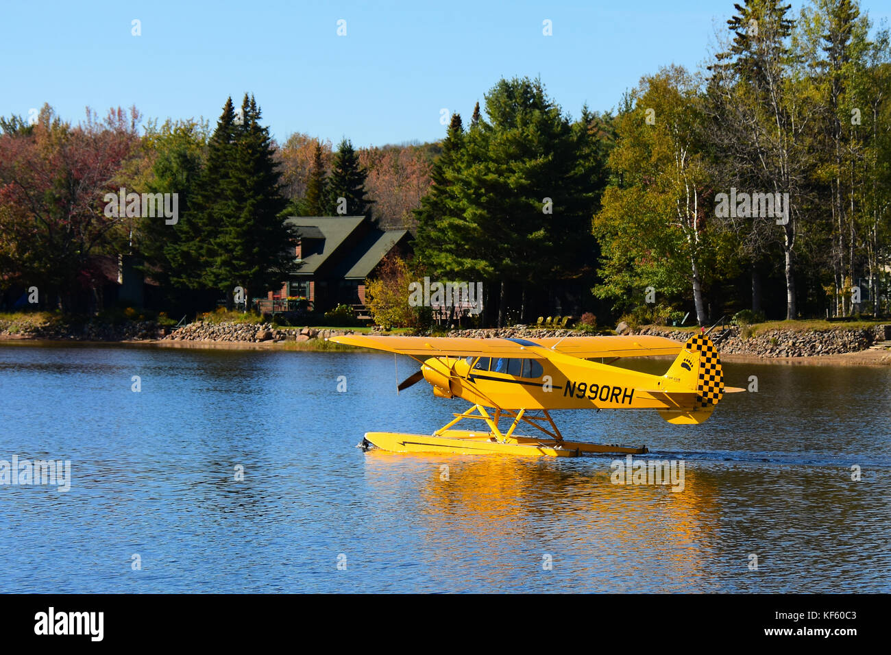 Bright yellow 2005 Cub Crafters float plane taxiing on Lake Pleasant in ...
