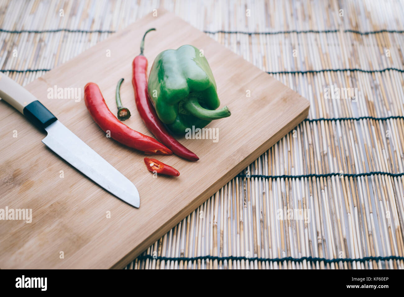 knife,pepper,chili and capsicum on a cutting board. vegetables on ...