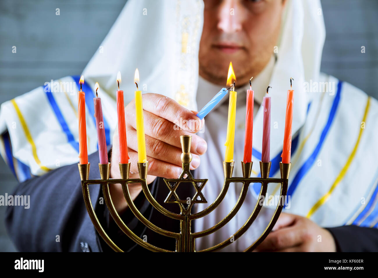 man hand lighting candles in menorah on table served for hanukka man ...