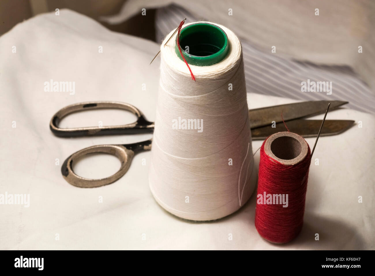 Sewing thread spools with needles and scissors Stock Photo - Alamy