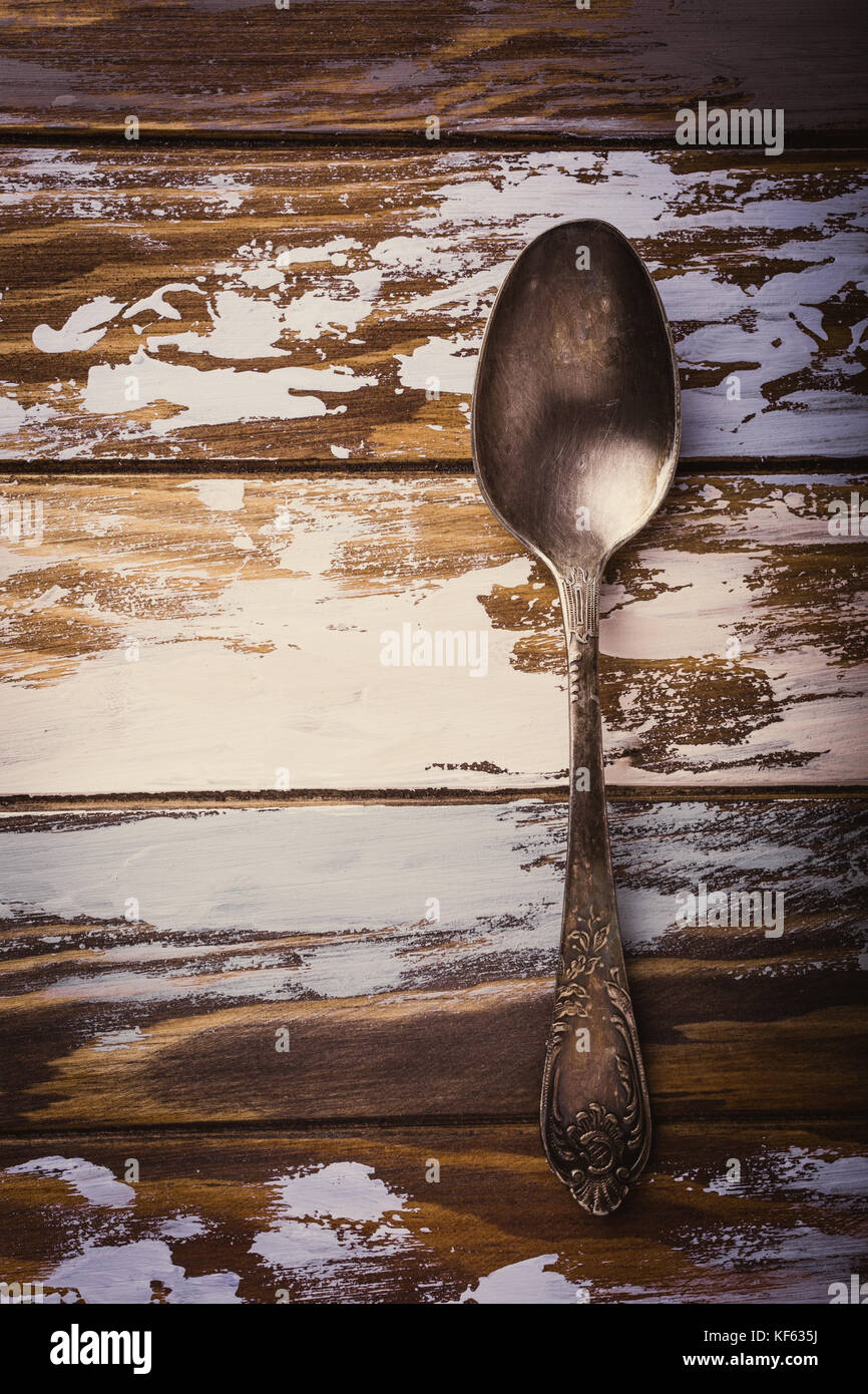 Metal spoon on old wooden grunge background Stock Photo - Alamy