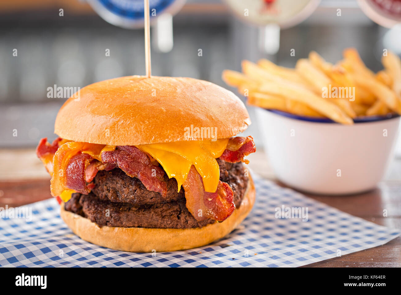 Double beef burger with cheese and bacon, bowl of fries Stock Photo - Alamy
