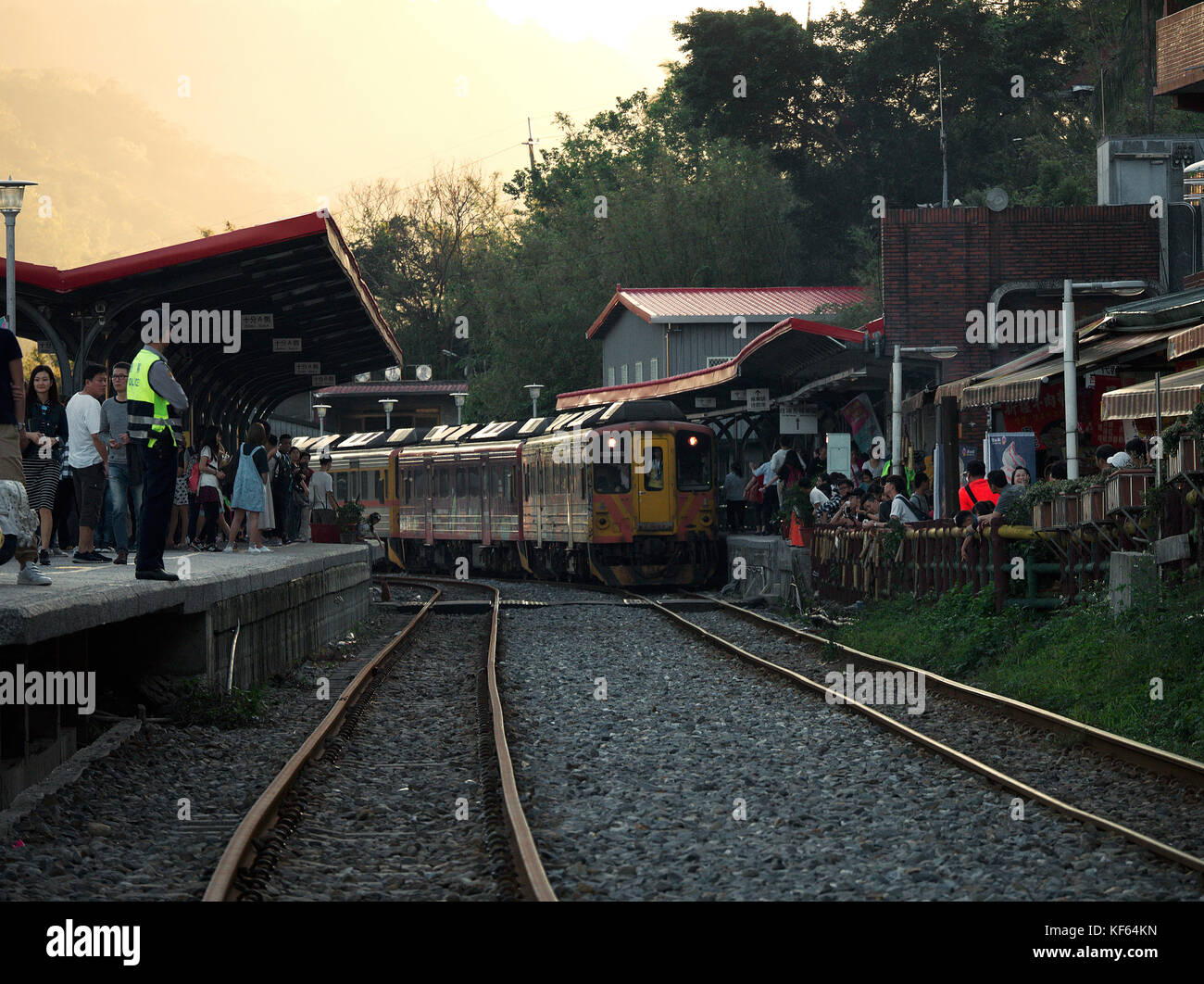 Train stopping at Shifen Station with throngs of tourists looking ...