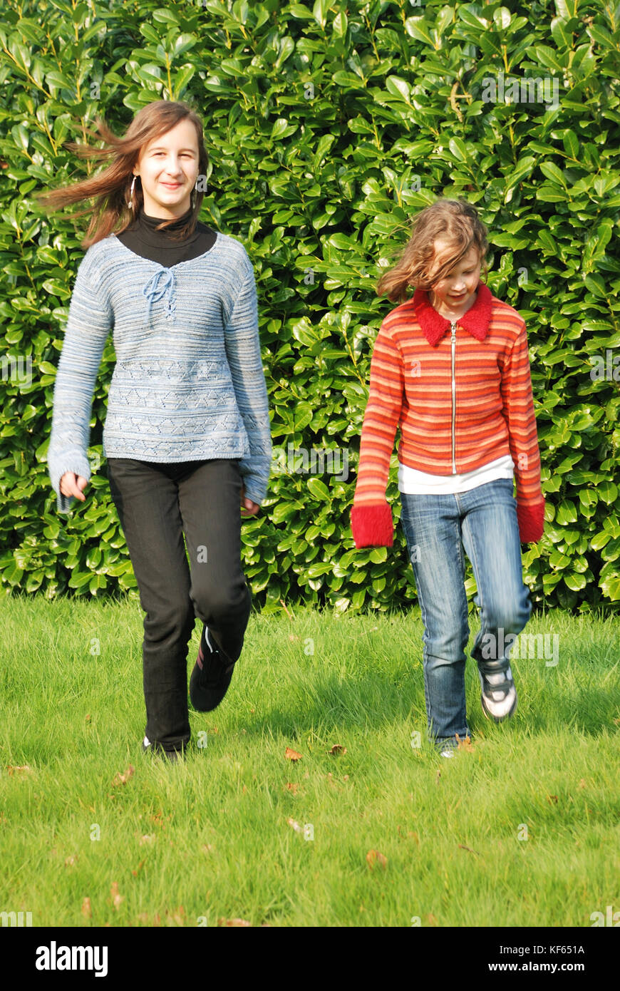 Girls running in the garden Stock Photo - Alamy
