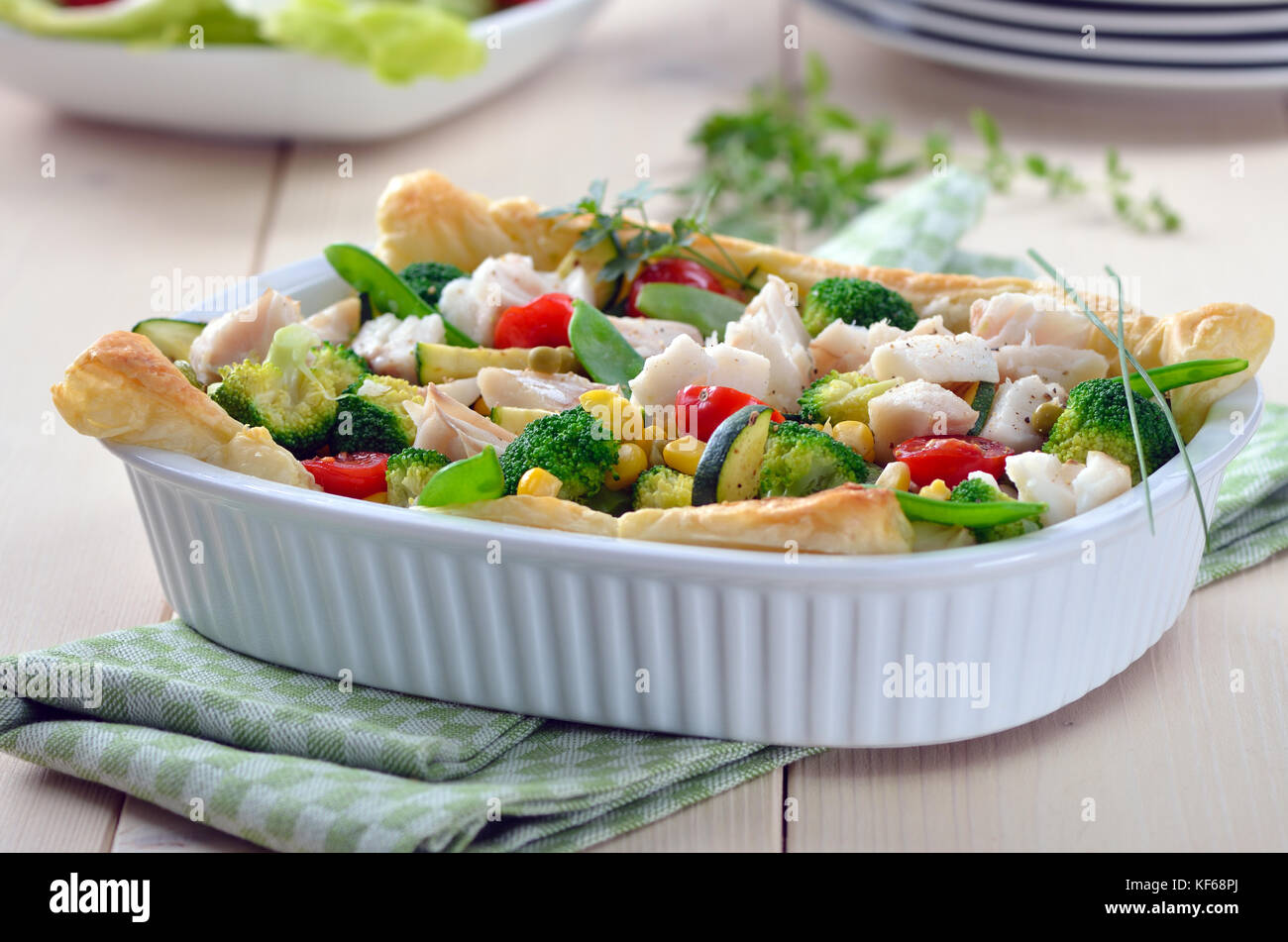 Cod fillet on mixed vegetables in season baked on puff pastry Stock ...