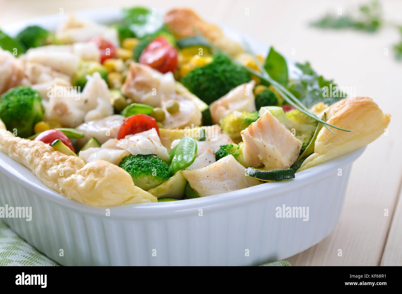 Cod fillet on mixed vegetables in season baked on puff pastry Stock ...