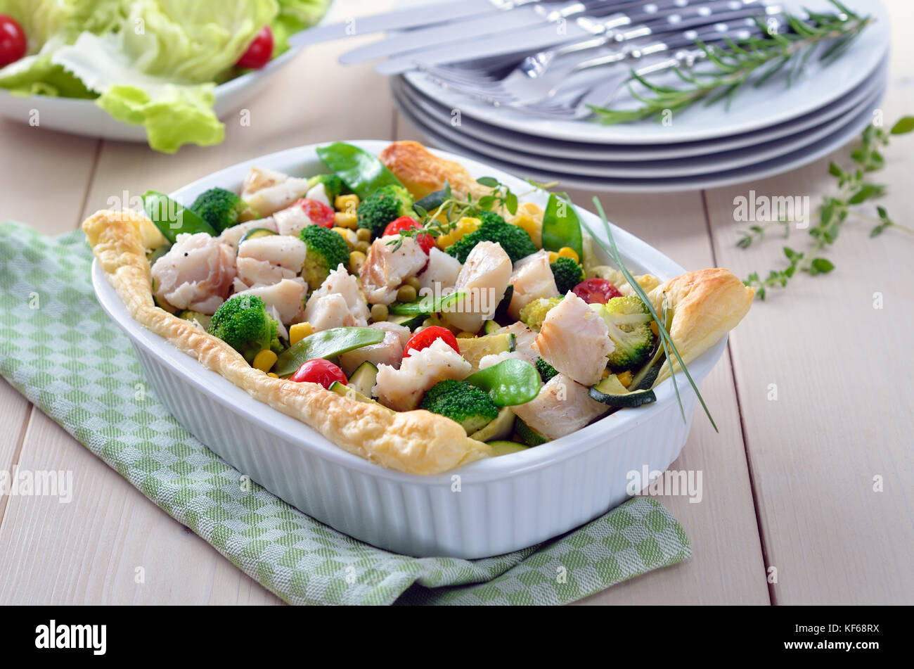 Cod fillet on mixed vegetables in season baked on puff pastry Stock ...