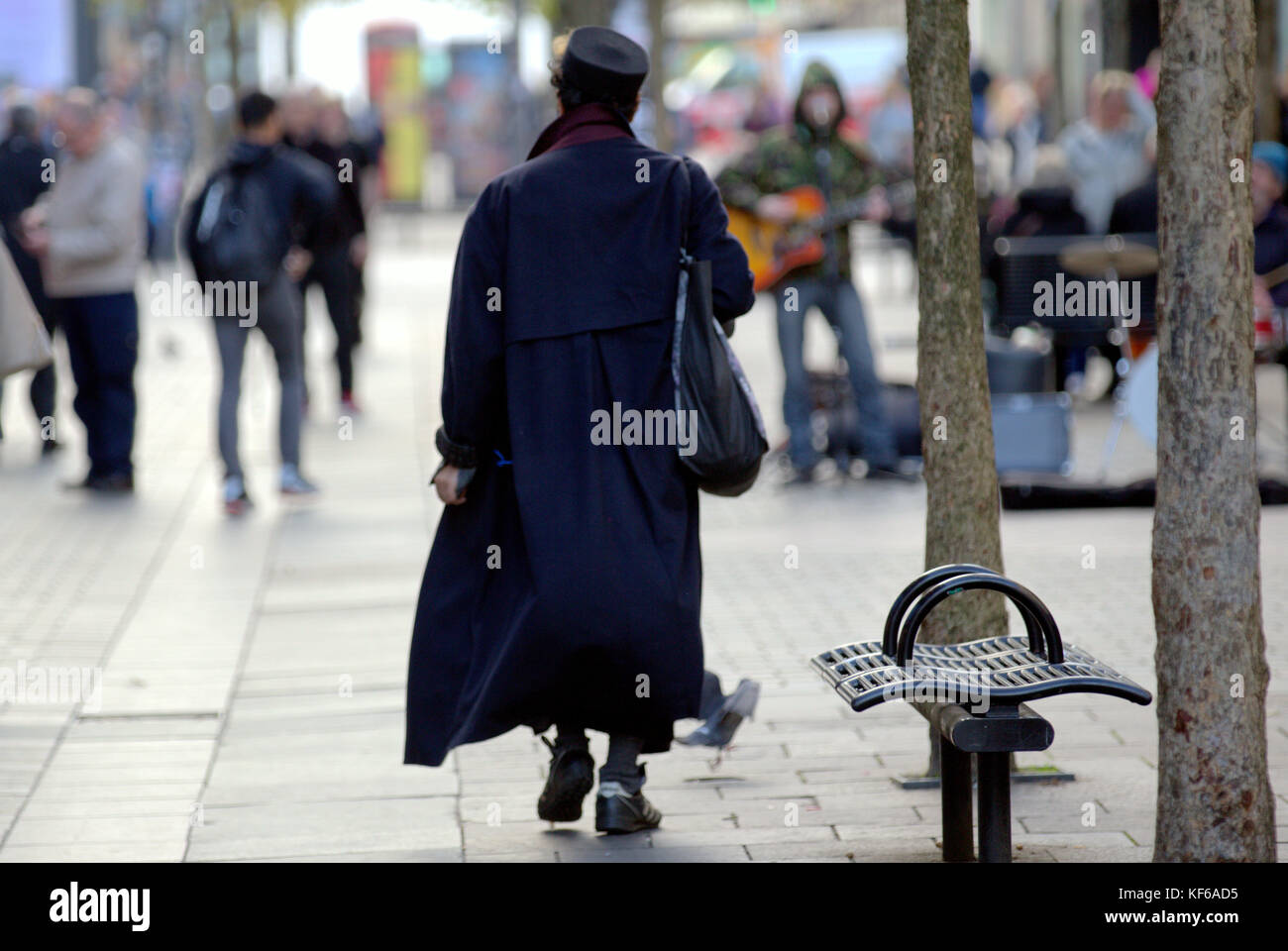 asian pakistani religious man walking viewed from behind glasgow street ...