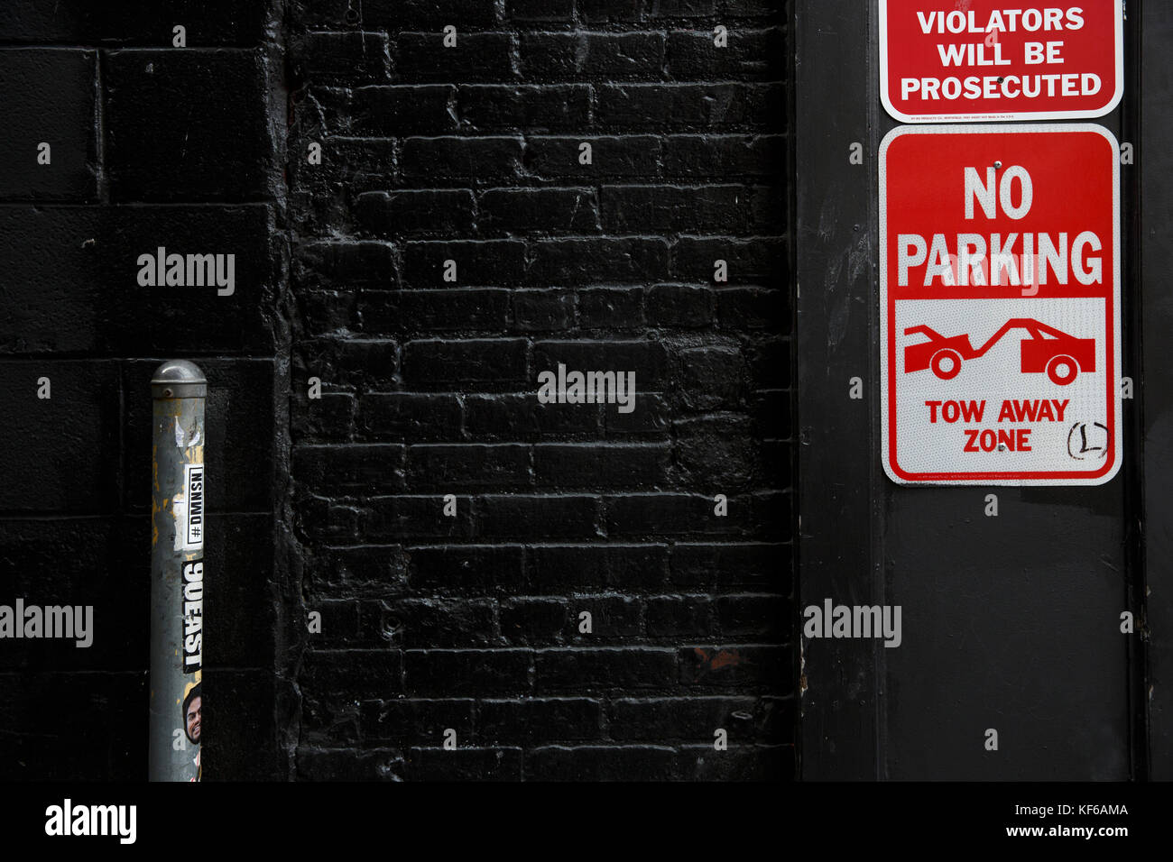 Red no parking restriction sign black brick wall Stock Photo - Alamy