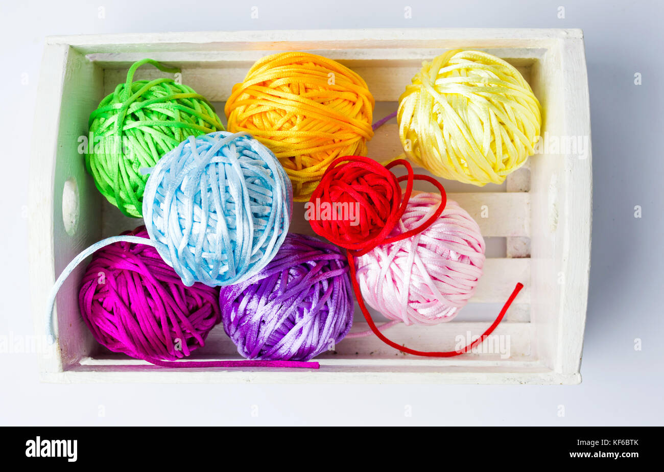 Colorful knitting thread balls on white table Stock Photo - Alamy