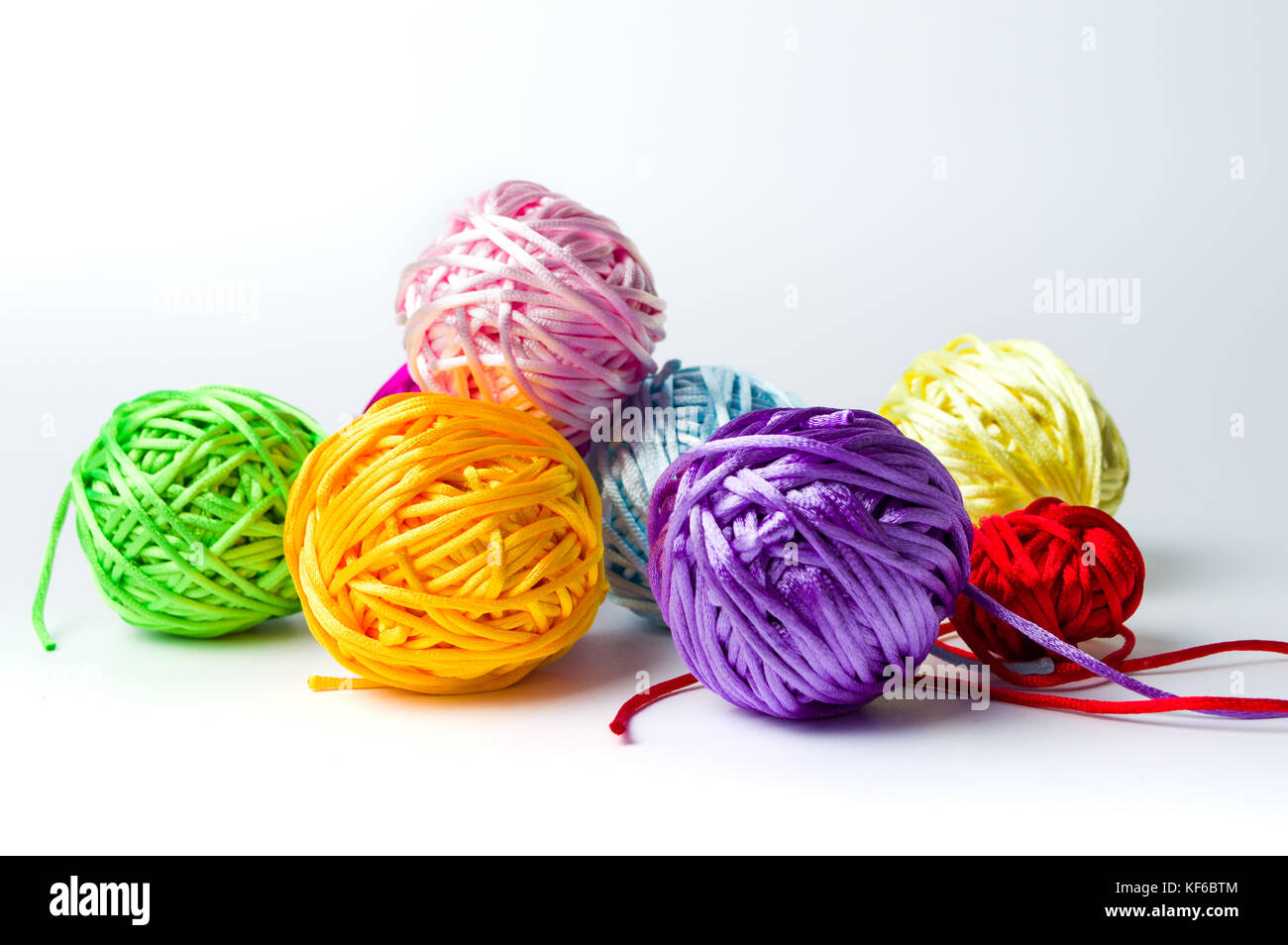 Colorful knitting thread balls on white table Stock Photo - Alamy