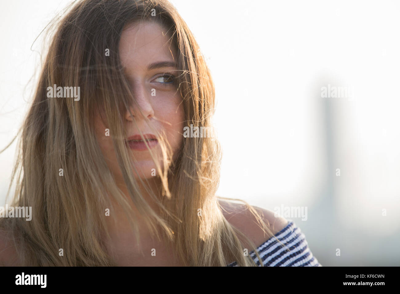 Close up portrait of a woman looking away outdoors hair covering face ...