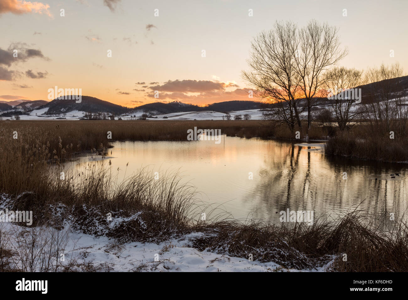 A lake shore in Colfiorito (Umbria) in winter with snow, trees ...