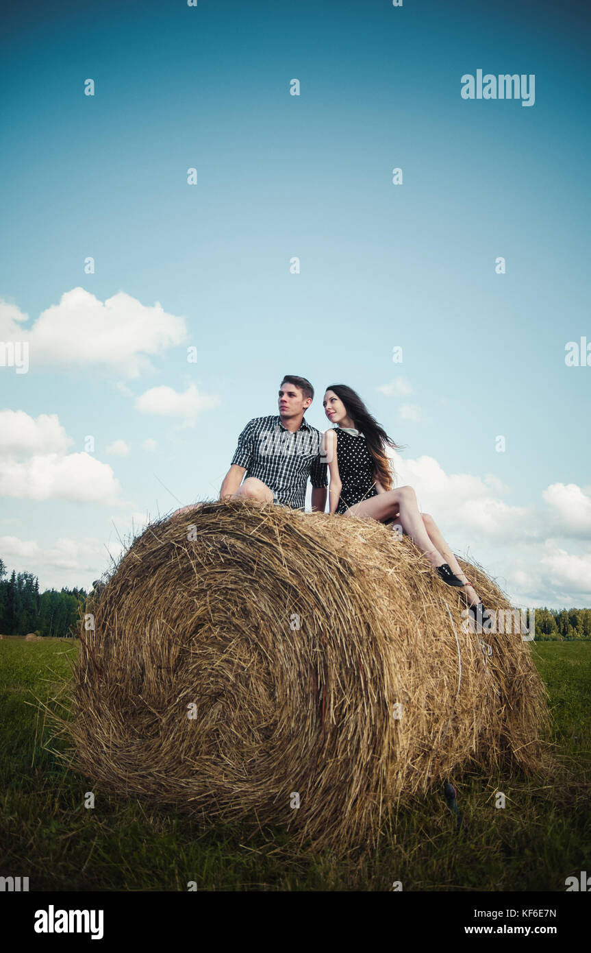 lovers resting in a field near haystacks.Outdoor portrait Stock Photo ...