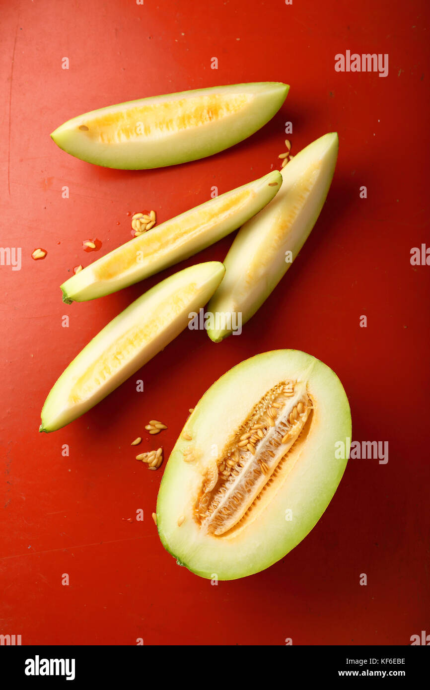 Ripe yellow melon slices on red background, food top view Stock Photo ...