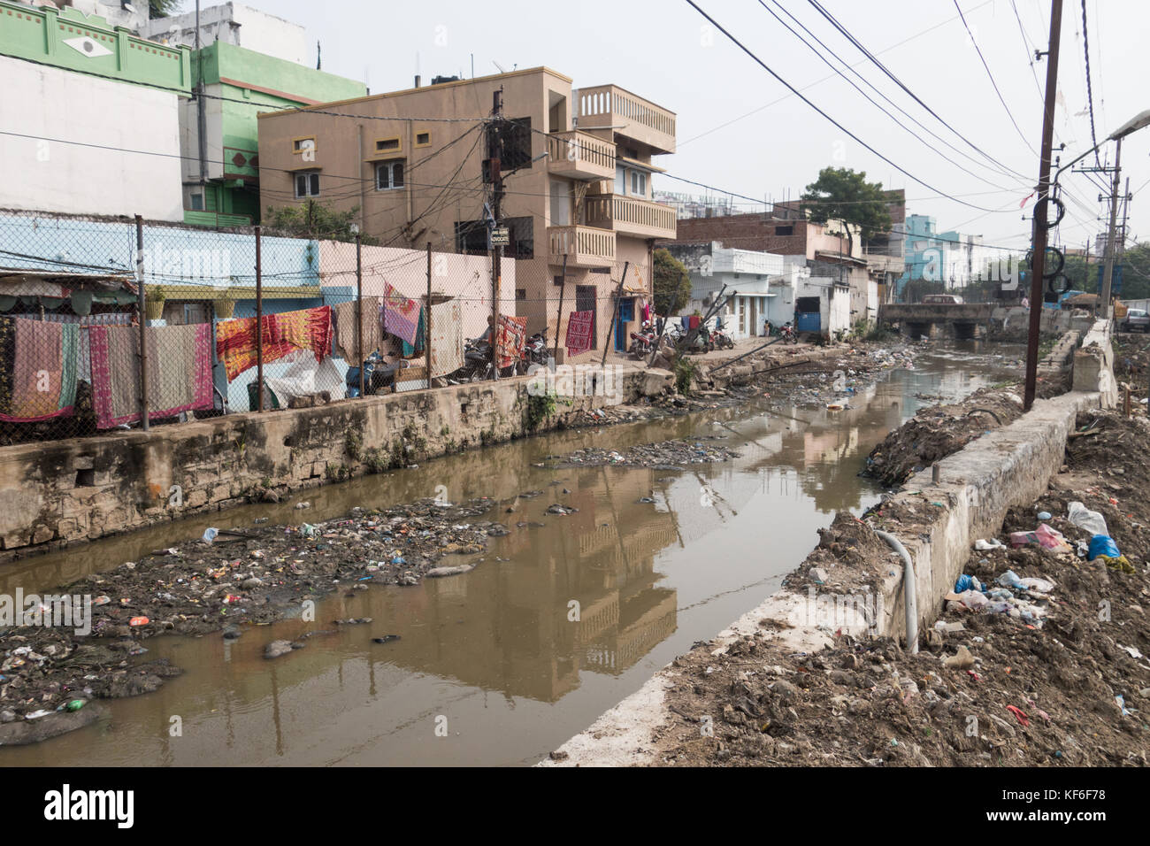 HYDERABAD, INDIA - OCTOBER 22,2017 Houses stand alongside a open sewage ...