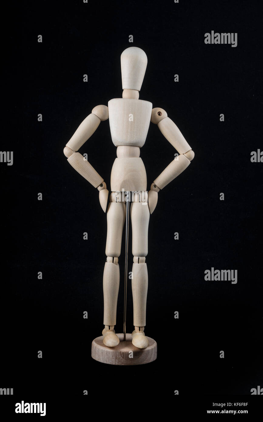 a wooden dummy with hands to sides on a black background Stock Photo ...