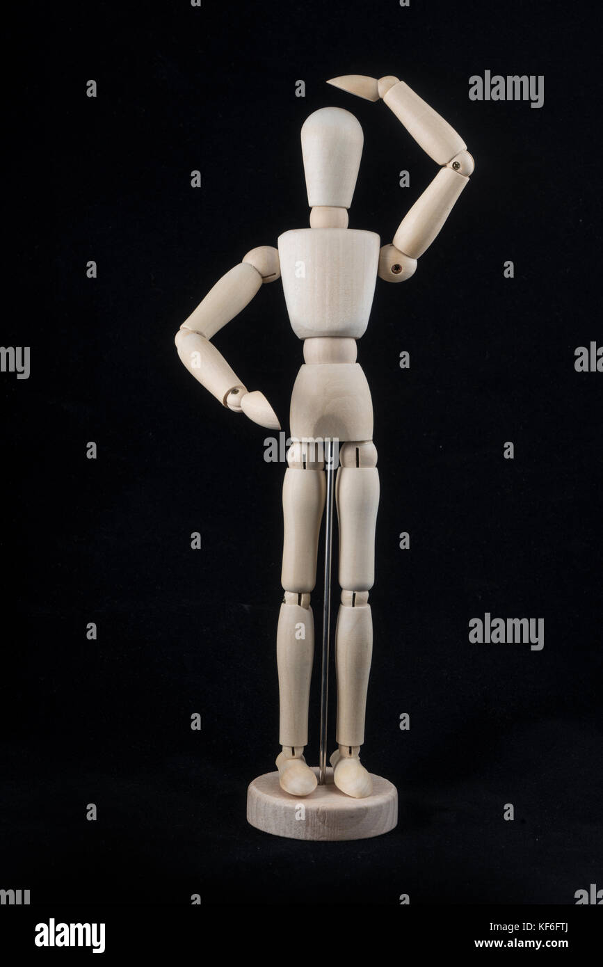 a wooden dummy posing with a hand on the head Stock Photo - Alamy