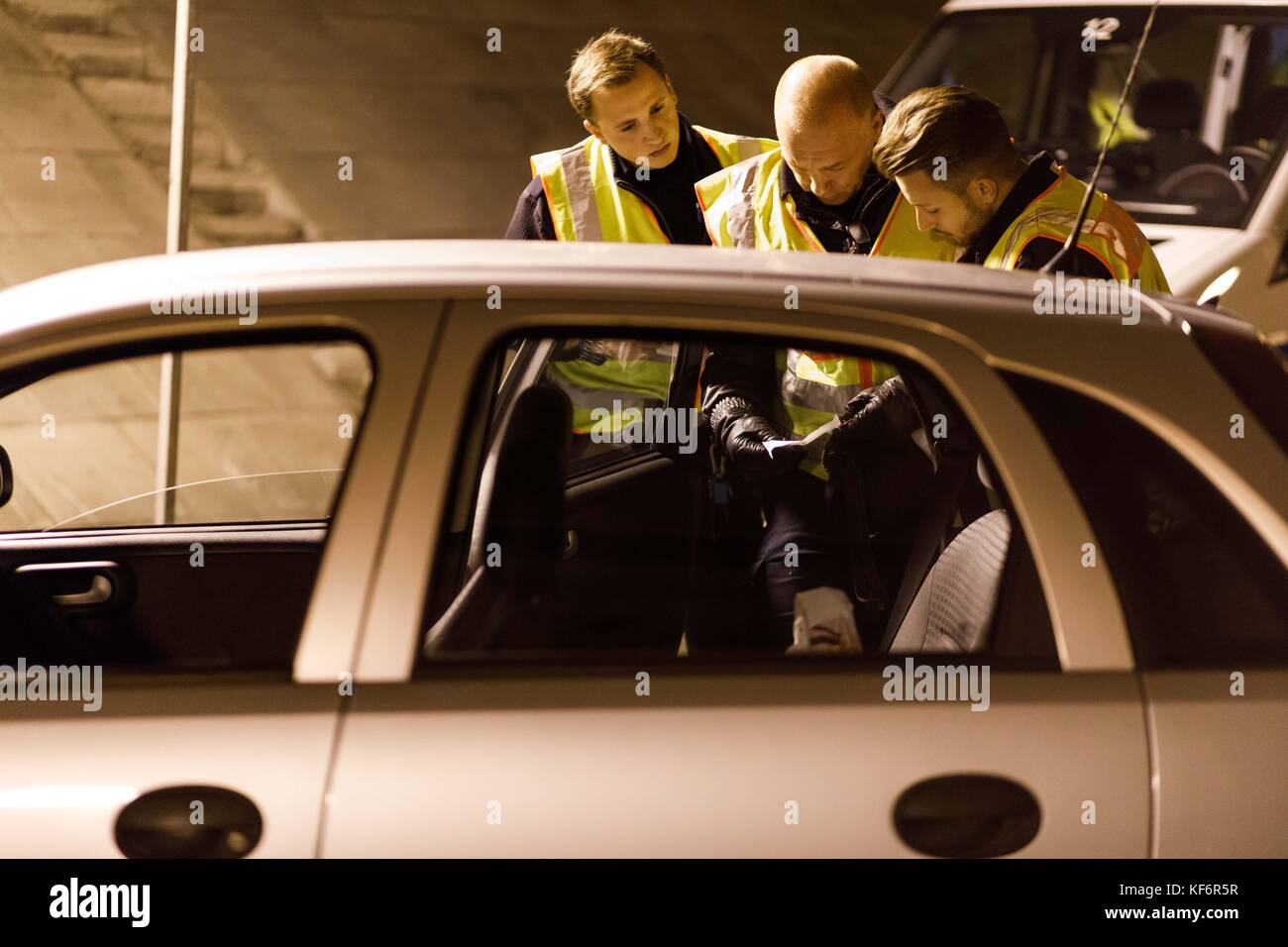 Police officers carry out roadside inspections of vehicles passing ...