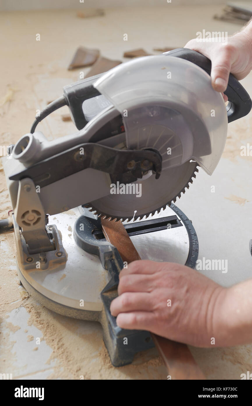 Worker cuts walnut baseboard on the miter saw Stock Photo - Alamy