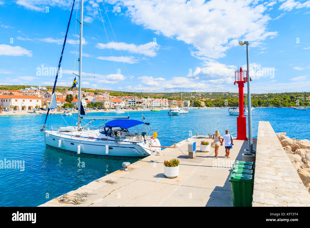 Couple of unidentified tourists walking in beautiful Primosten sailing ...