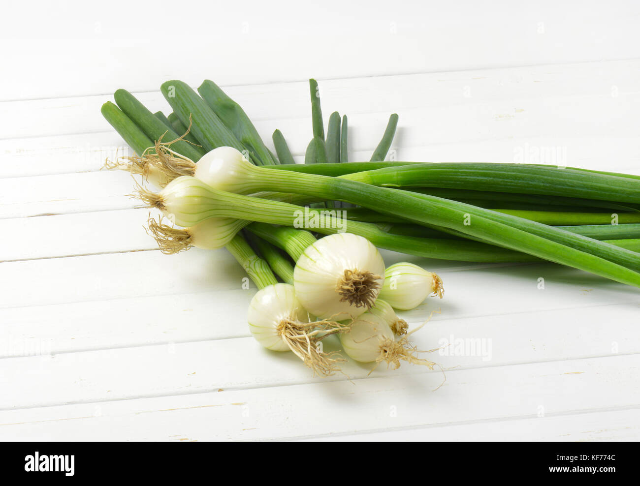 two bunches of spring onion on white wooden background Stock Photo - Alamy