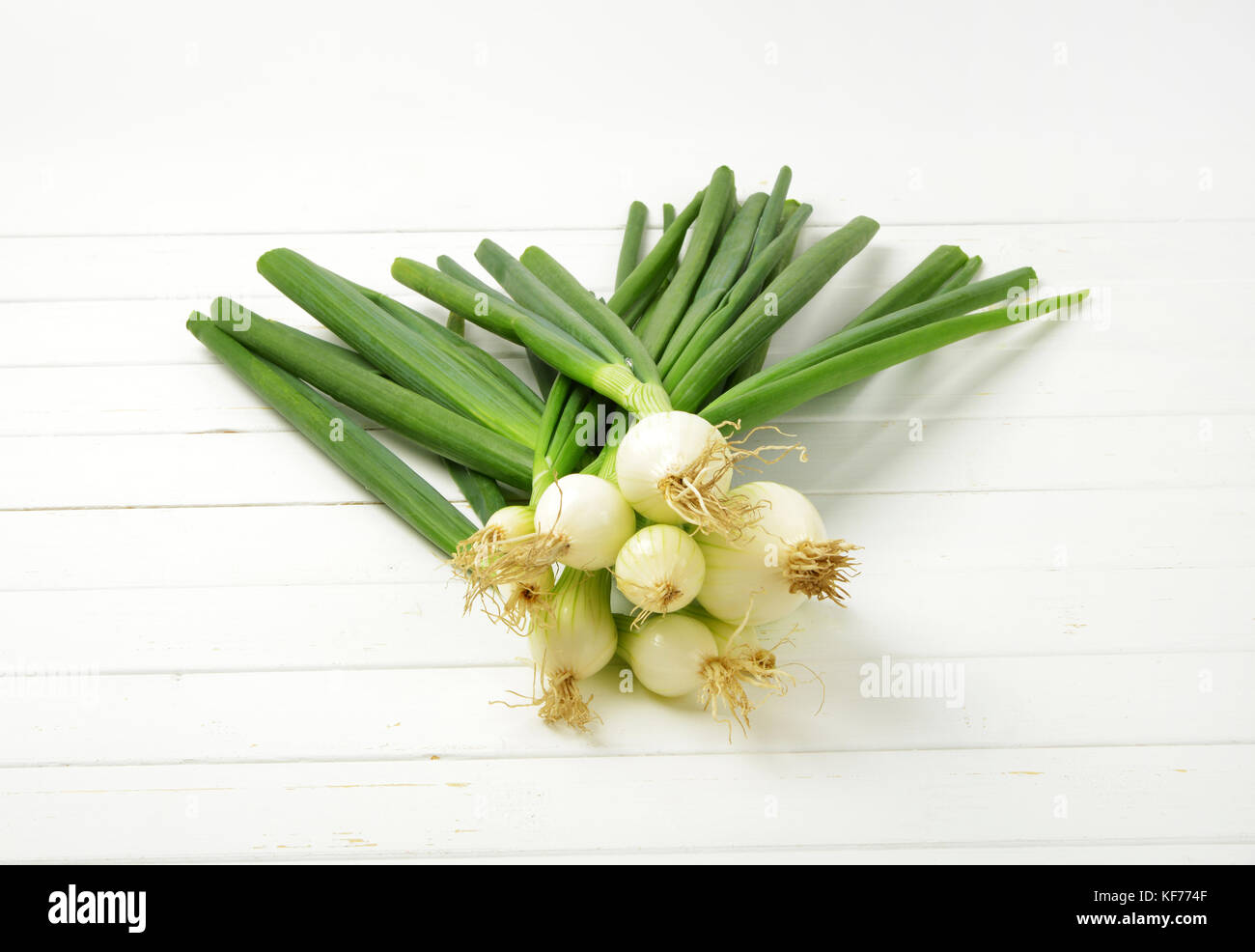 bunch of spring onion on white wooden background Stock Photo - Alamy