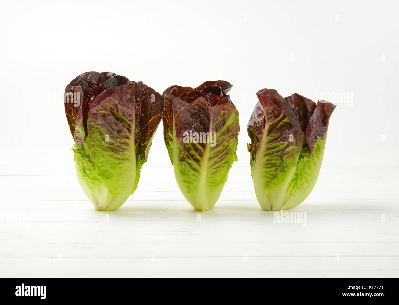 three heads of fresh lettuce standing on white wooden background Stock ...