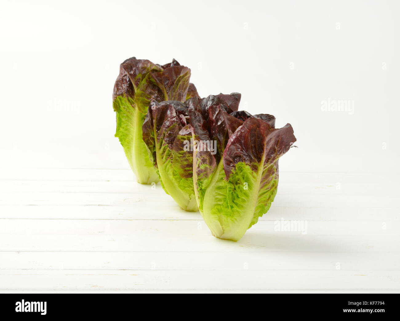 three heads of fresh lettuce standing on white wooden background Stock ...