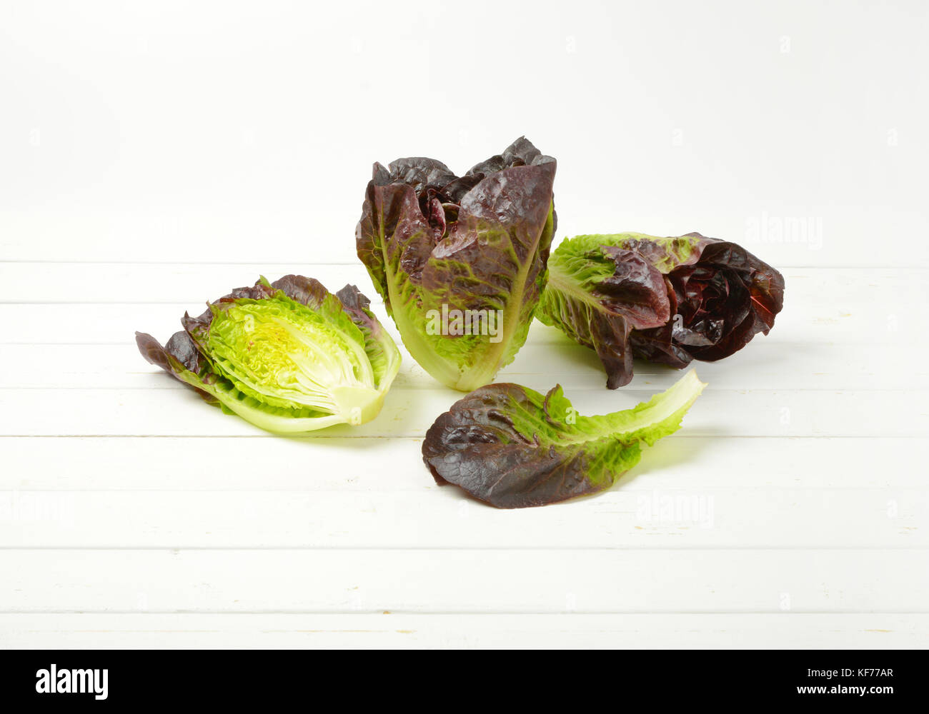 two and half heads of fresh lettuce on white wooden background Stock ...
