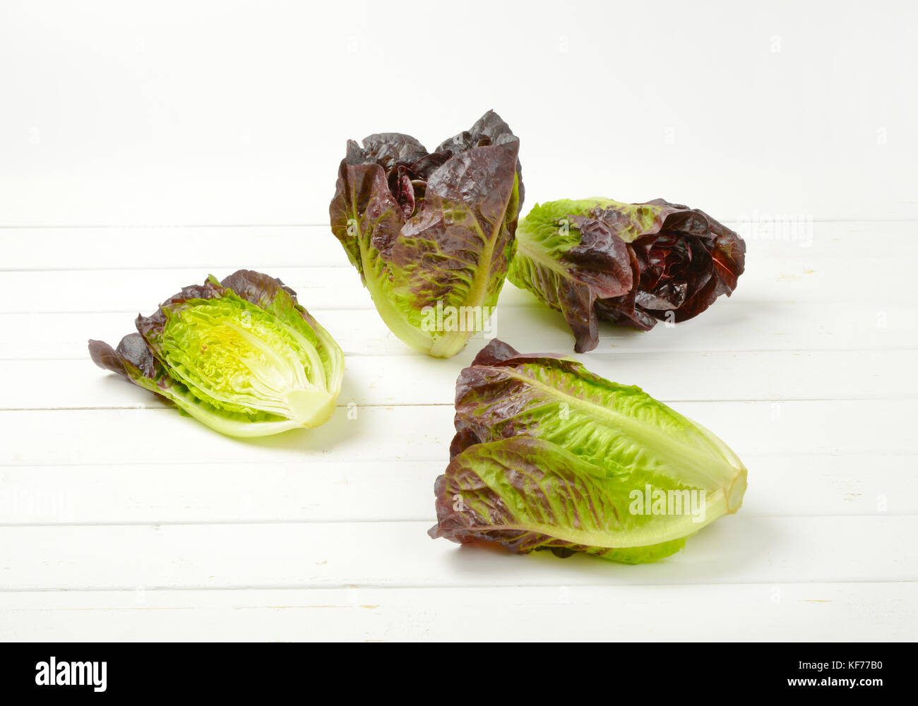 three and half heads of fresh lettuce on white wooden background Stock ...