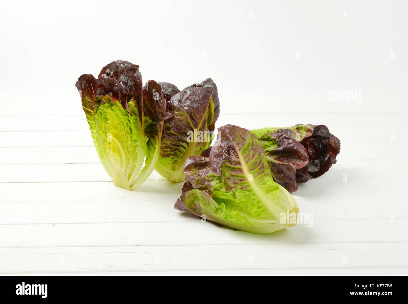 three and half heads of fresh lettuce on white wooden background Stock ...