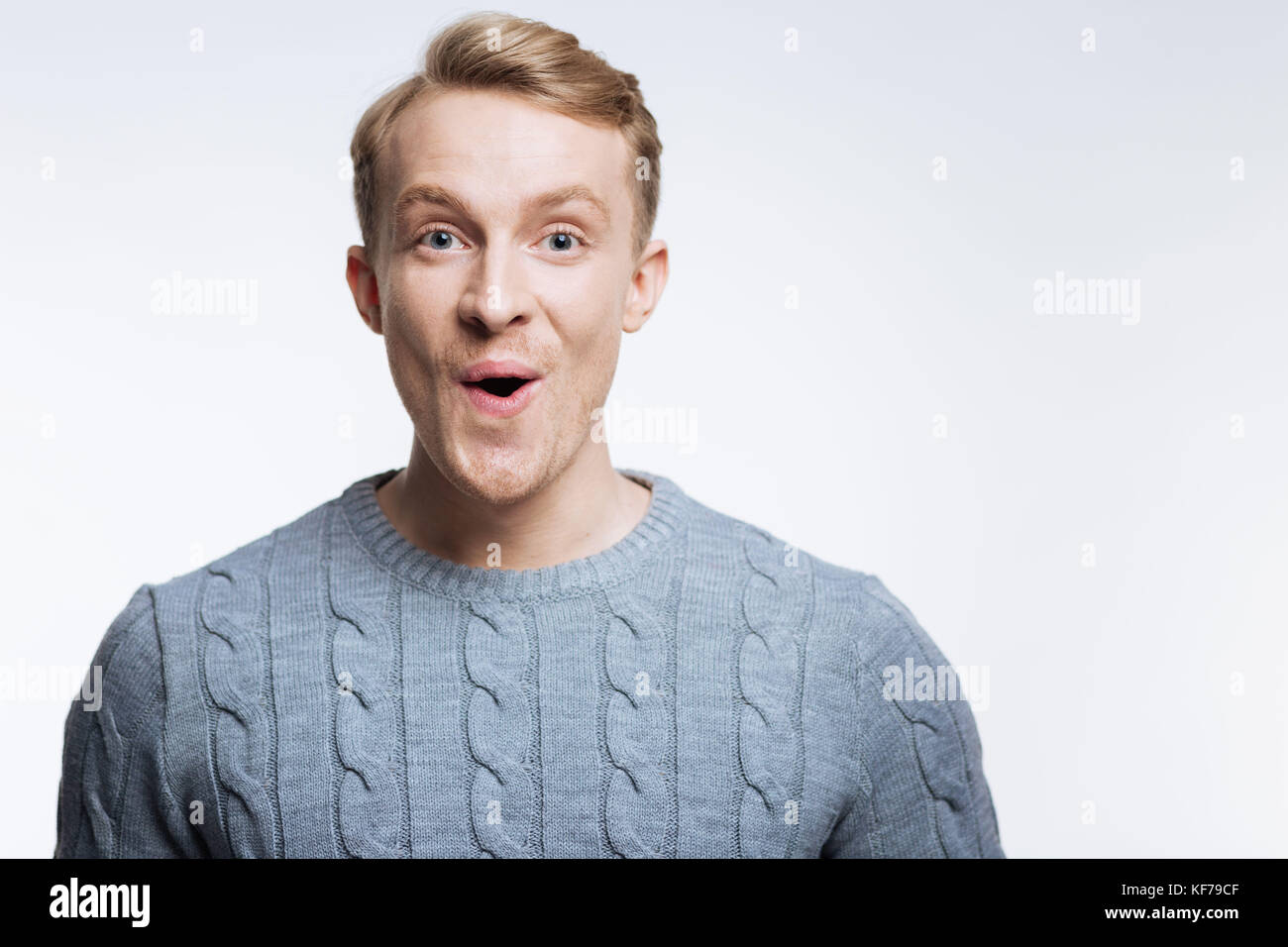Fair-haired young man looking surprised Stock Photo - Alamy