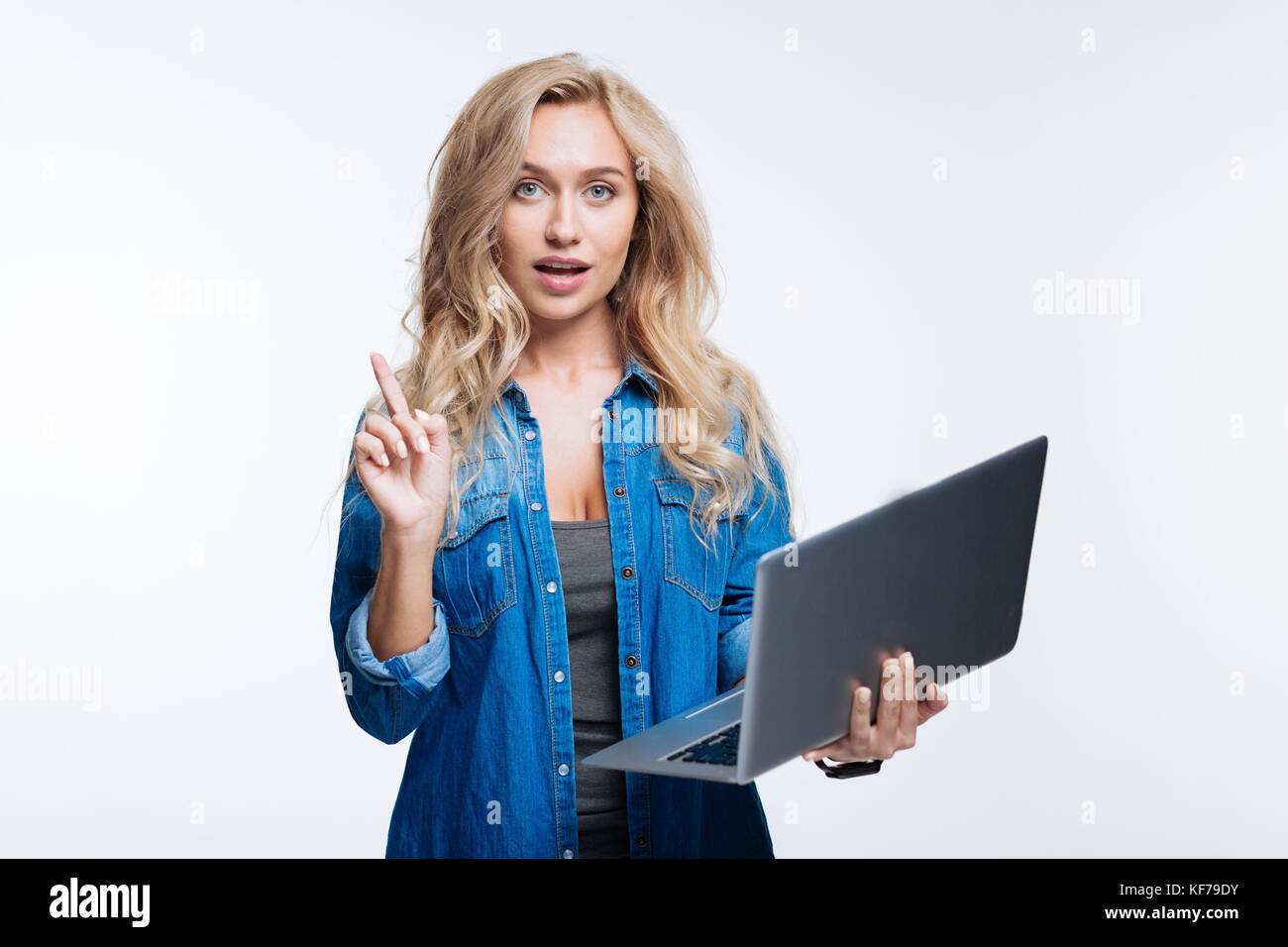 Pleasant woman making remark while holding laptop Stock Photo - Alamy