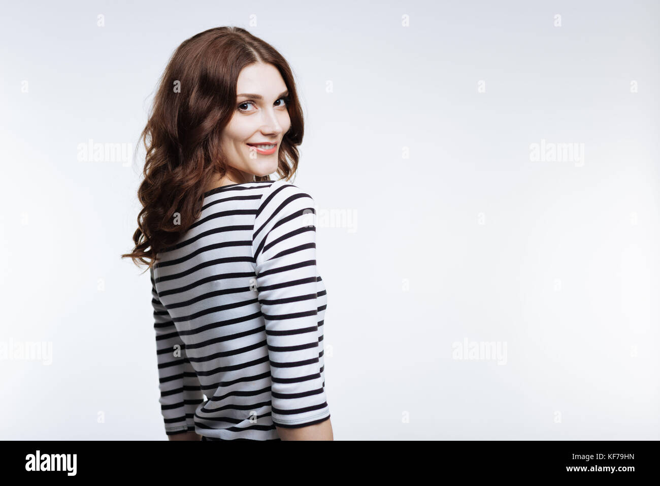 Joyful pretty woman posing while standing half-turned Stock Photo - Alamy