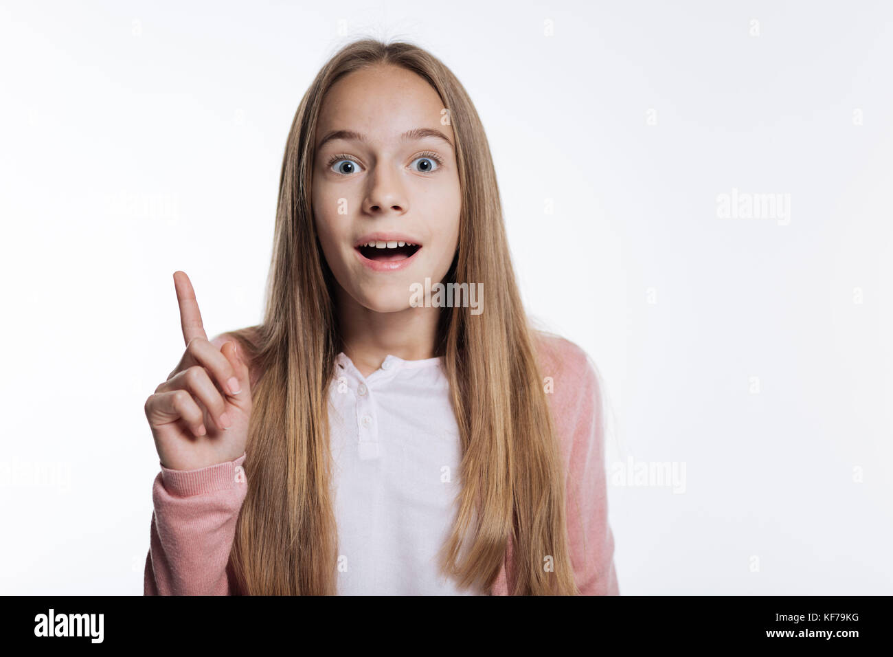 Teenage girl raising her finger to indicate new idea Stock Photo - Alamy