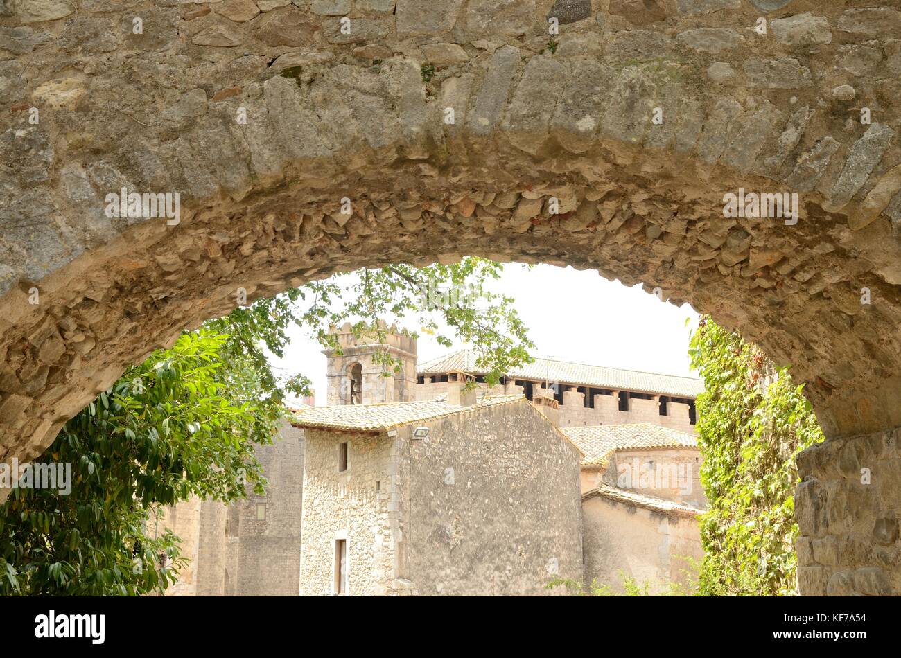 Stone buildings through arch in the medieval city of Girona, Catalonia ...