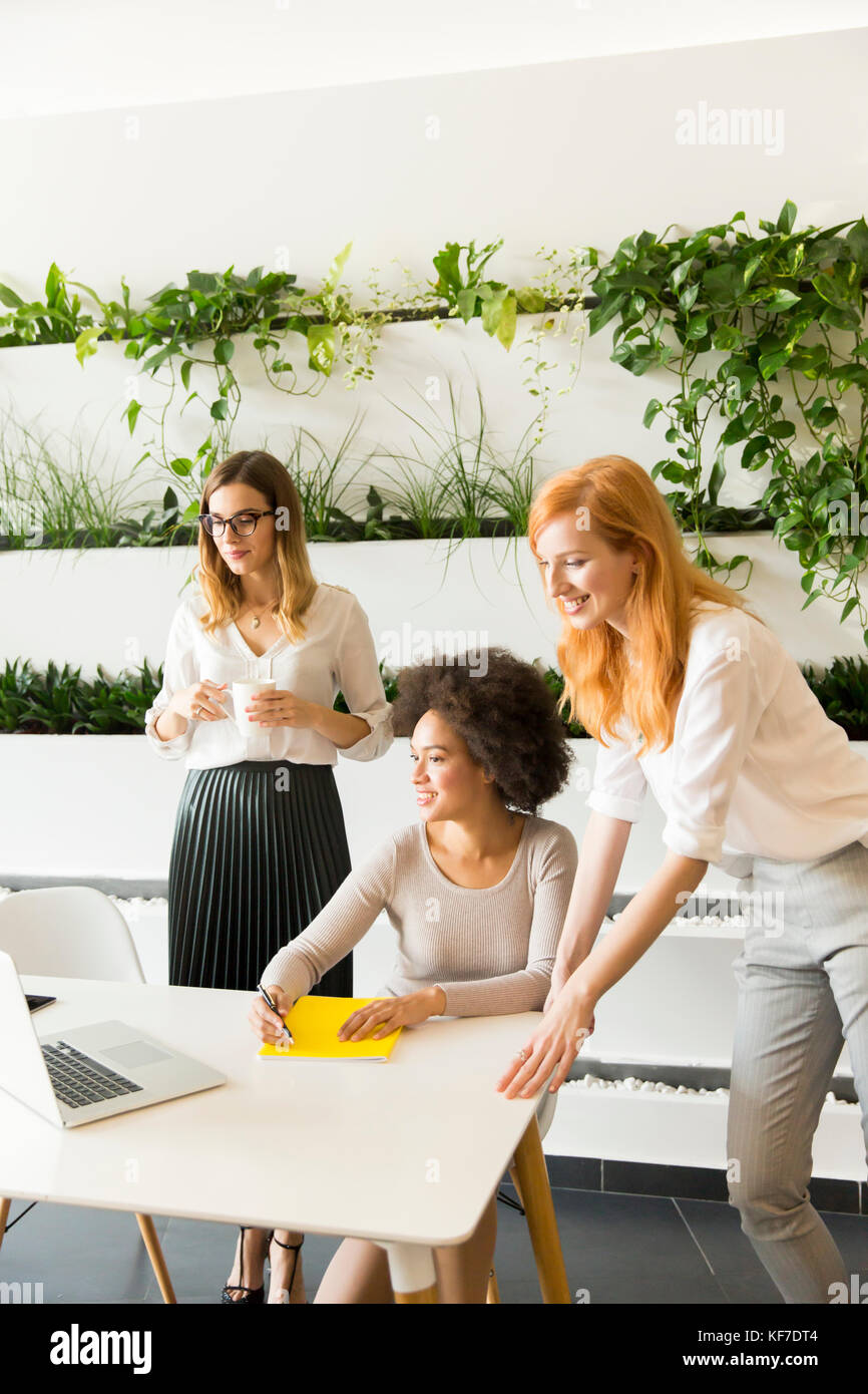Three young businesswomen working together in the office Stock Photo ...