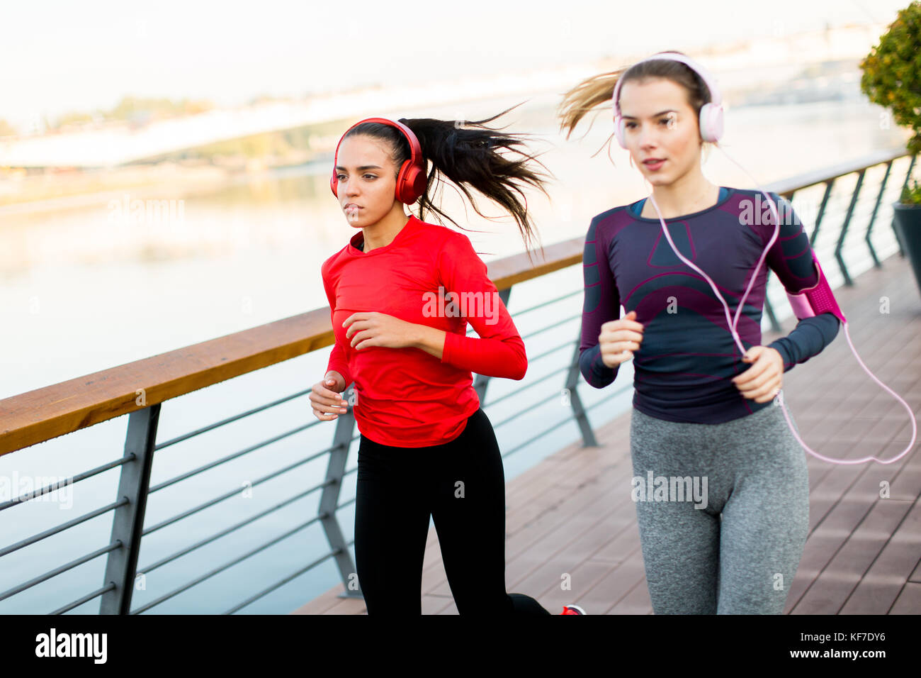 Two young women running by the river in the morning Stock Photo - Alamy