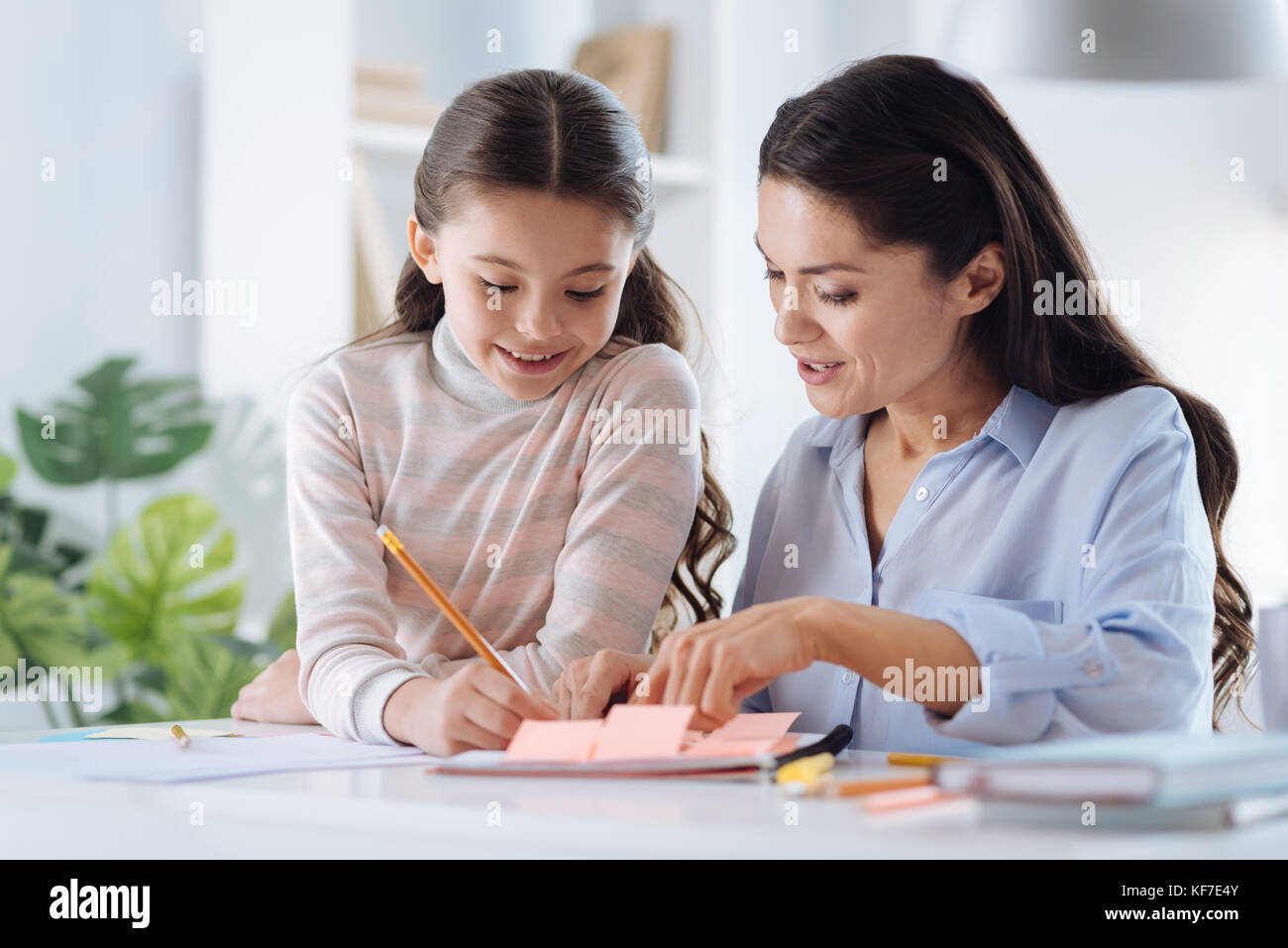Delighted positive woman helping her daughter Stock Photo - Alamy