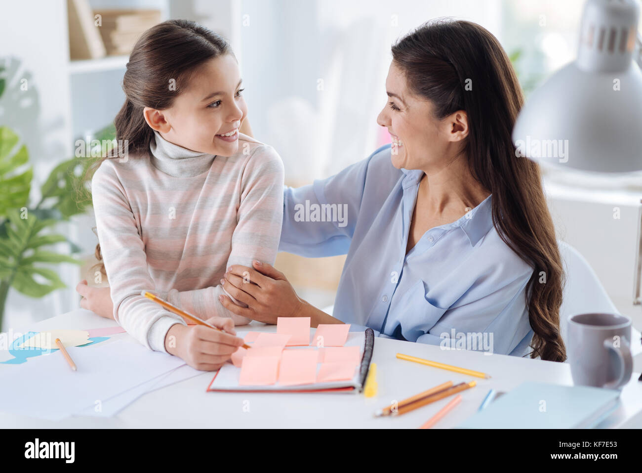 Joyful happy girl doing her home assignment Stock Photo - Alamy