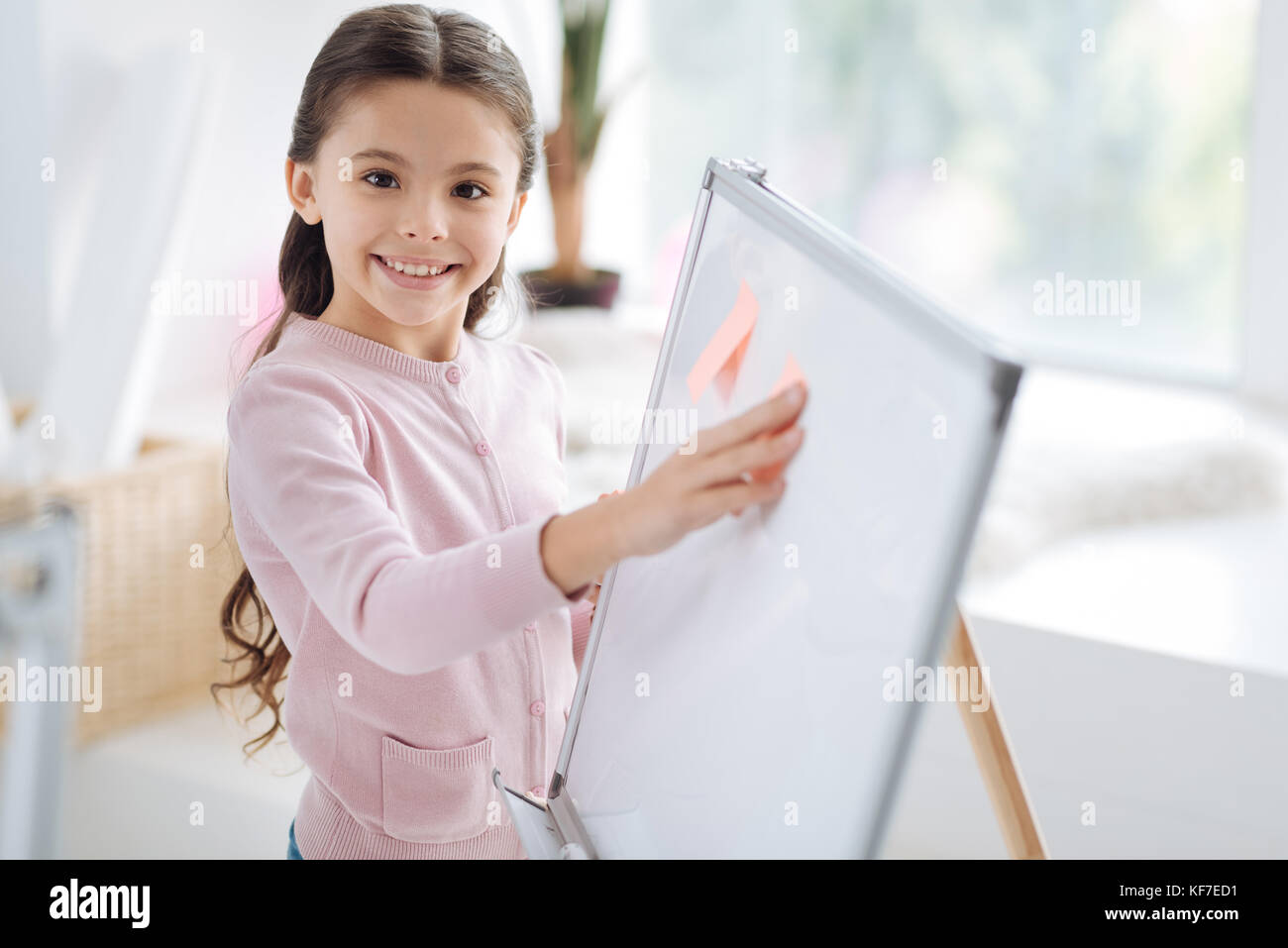 Happy cute girl putting sticky notes on the whiteboard Stock Photo - Alamy