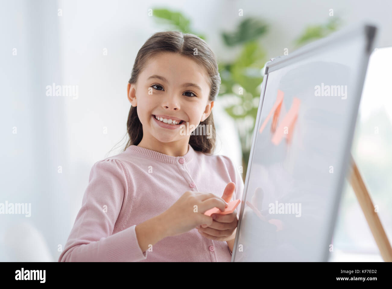 Cute positive girl standing near the whiteboard Stock Photo - Alamy
