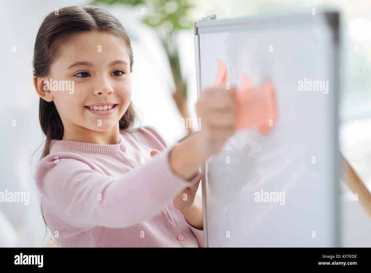 Happy cheerful girl holding a sticky note Stock Photo - Alamy