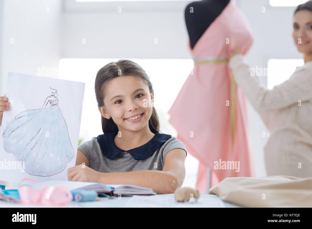 Delighted positive girl presenting her drawing Stock Photo - Alamy