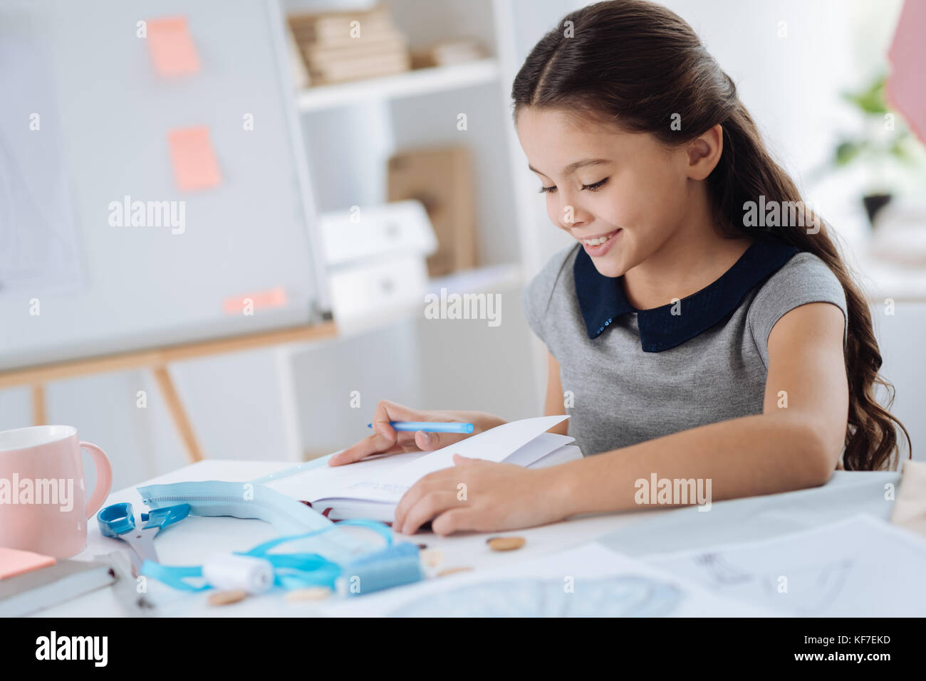 Cute happy girl holding a pen Stock Photo - Alamy