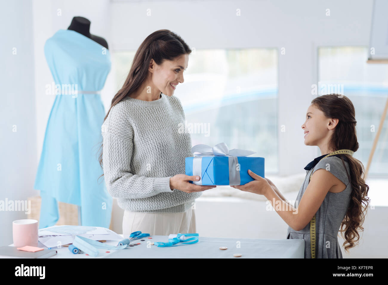 Joyful young woman getting a present from her daughter Stock Photo - Alamy