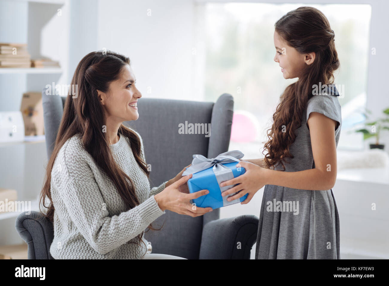 Delighted attractive woman receiving a gift Stock Photo - Alamy