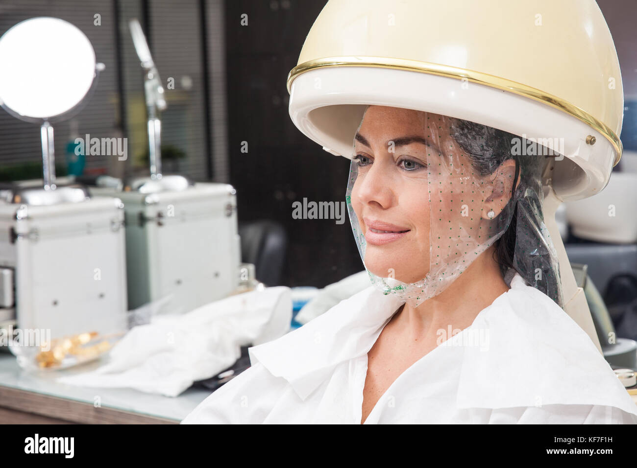 Woman under a professional hair steamer with a hair treatment Stock ...