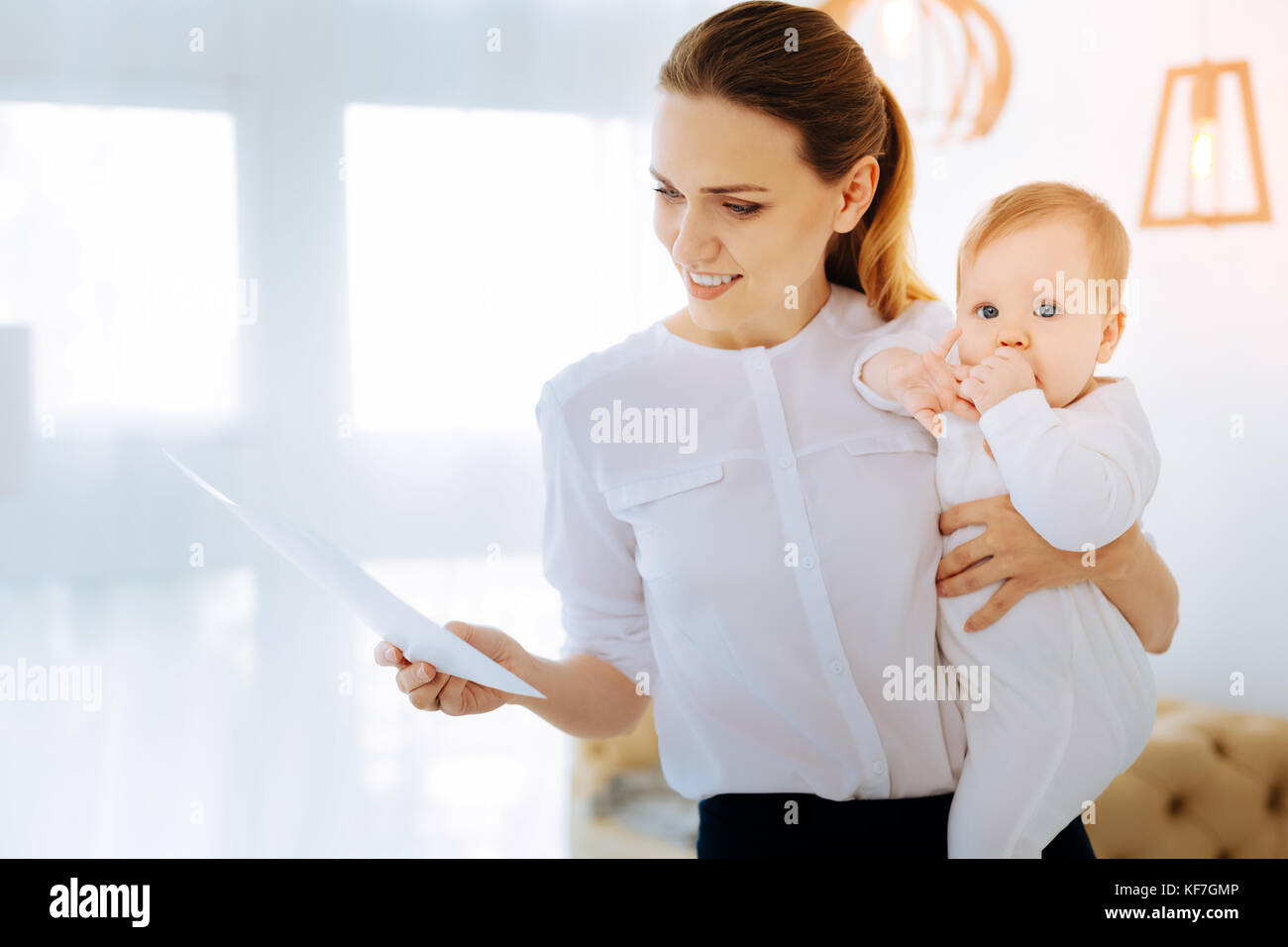 Cheerful young mother looking at her documents Stock Photo - Alamy